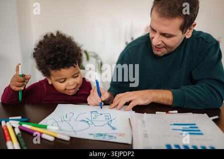 Father and child drawing together with colorful markers, sharing a ...