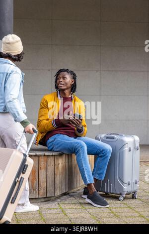 A woman wearing a yellow jacket and gray pants sits in a meditative ...