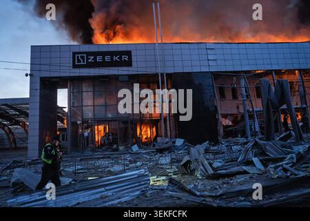 Ukrainian police officer walks pass by a burning building after a large ...