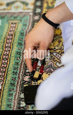 PRODUCTION - 27 May 2026, Berlin: A worshipper sits on a prayer mat ...