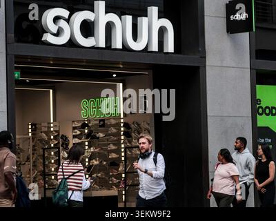 Schuh logo is seen as people walk in front of the shop on landmark ...