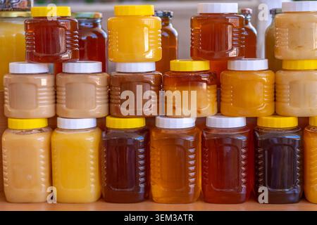 Jars of various honeys on wooden shelves. Ginger honey, sea buckthorn ...