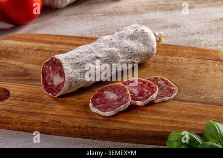 Appetizing still life of sliced fuet, a dry cured sausage, on a rustic ...