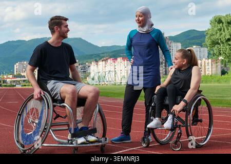 Smiling Female Wheelchair Athlete and Coach on Outdoor Running Track at ...