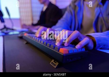 Cropped hands typing on mechanical gaming keyboard for digital ...