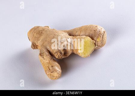 Fresh ginger root with exposed yellow interior placed on weathered ...