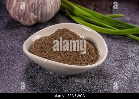 Ground black pepper piled in triangular white bowl. Garlic bulb green ...