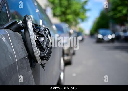 08 June 2026, Berlin: A worn wing mirror is hanging on a car. Photo ...