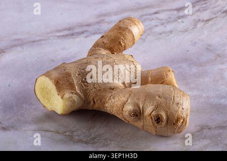 Fresh ginger root with exposed yellow interior placed on weathered ...