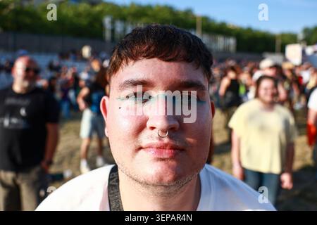 Festival goer with face paintings watches the concerts on the third day ...