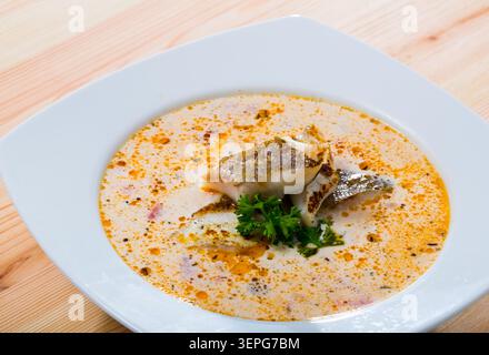 Tasty creamy soup with white fish hake and greens at plate Stock Photo ...