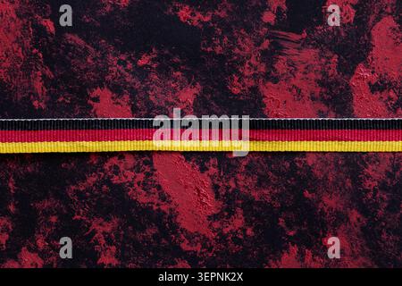 German flag colored ribbon on beige background in a design with copy ...