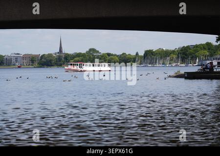 Hamburg, Germany. 16th June, 2026. Passersby are enjoying the sunny ...