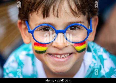 A supporter with face paint reacts while watching the Portugal vs DR ...