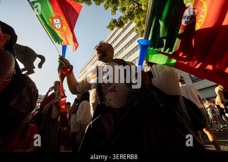 A street vendor holds Portuguese flags while working near the Fan Zone ...