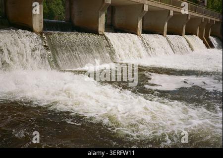 Dynamic stream water with frothy rapids, reflecting sunlight and ...