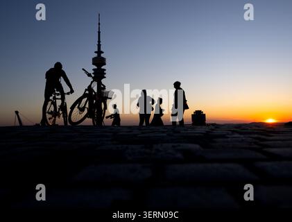 Munich, Germany. 19th June, 2026. Early risers watch the sunrise on ...