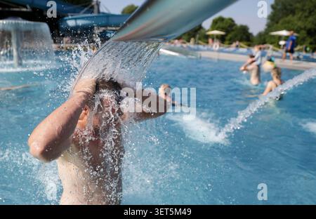 Sigmaringen, Germany. 21st June, 2026. A man is standing under a water ...