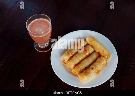 Five golden brown fried spring rolls arranged diagonally on textured ...