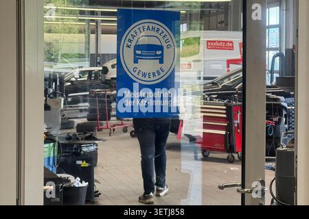View into a modern auto repair shop with vehicles on service bays and a ...