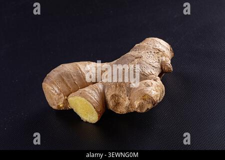 Fresh ginger root with exposed yellow interior placed on weathered ...