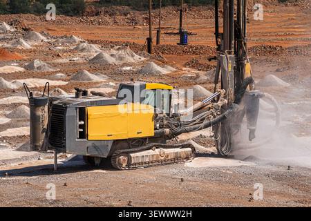 Crawler drill rig drilling blast holes in an open pit mine with heavy ...