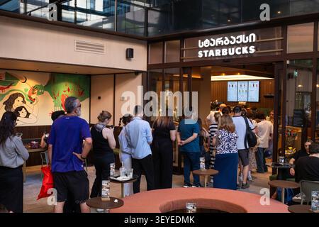 People line up outside the first Starbucks store on its opening day in ...