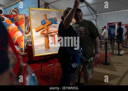 People pose for a selfie by a painting at the Great American State Fair ...