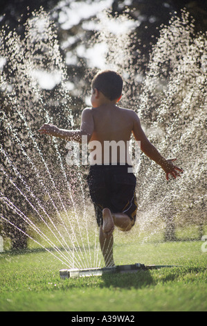 Boy running through sprinklers Stock Photo: 20245546 - Alamy