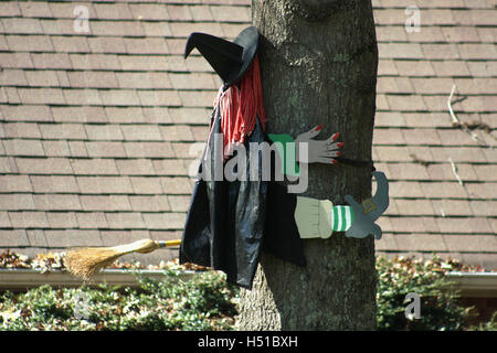Comical outdoor Halloween decoration of witch crushing into a tree ...