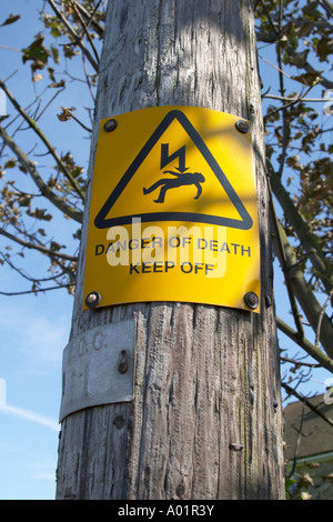 Yellow & black warning sign screwed to a brick wall to warn about a ...
