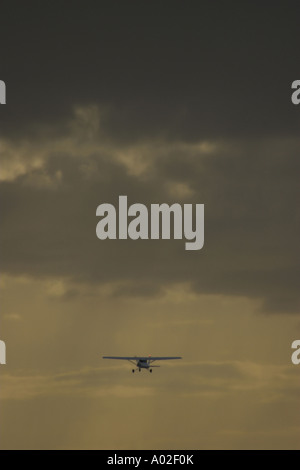 A small plane flying towards an incoming storm Stock Photo - Alamy