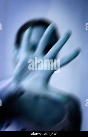 Frightened woman shielding her face with her hands Stock Photo - Alamy