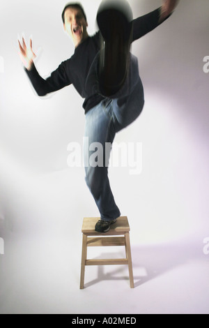Man stood on stool losing his balance and about to fall over Stock ...