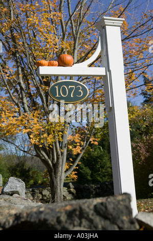 Sign with numbers of the house number, new wooden fence in a country ...