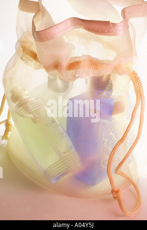 Cosmetic bag, bottles of perfume and gift box on wooden boards and gray ...