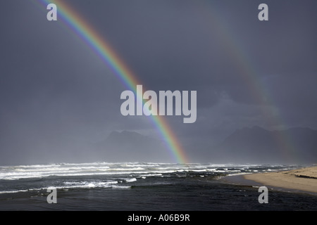 Bright Rainbow in stormy sky over forest Stock Photo - Alamy