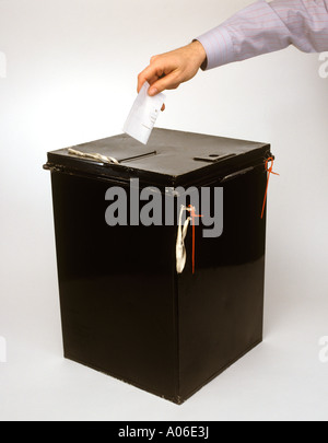 Ballot box, hand placing a vote into a ballot box, voting with ballot ...