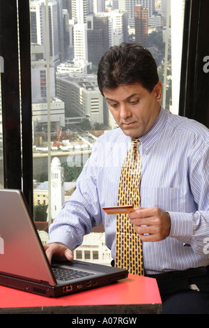 A man sitting at the laptop and paying by credit card online Stock ...
