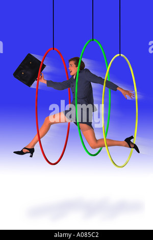 Businesswoman with briefcase jumping through hoops Stock Photo - Alamy
