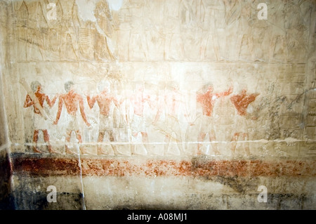 Tourists study ancient inscriptions inside a tomb at the Pyramid ...