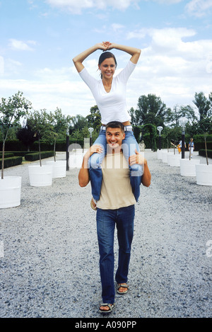 Woman riding on man's shoulders Stock Photo - Alamy