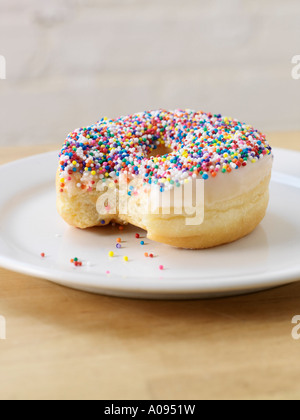 Close up view of bitten donut on white plate isolated on white ...