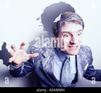 Frustrated businessman breaking through wall Stock Photo - Alamy