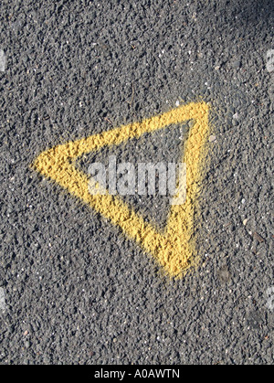 yellow triangle painted on road Stock Photo - Alamy