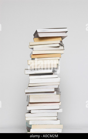 Many stacked books on white table and sofa indoors Stock Photo - Alamy
