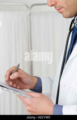Doctor writing in chart Stock Photo - Alamy