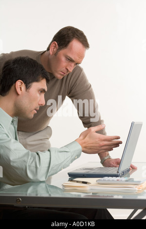 Two men discuss information in a folder with documents Stock Photo - Alamy