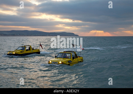 Two Dutton Commander amphibious cars with headlights on crossing the ...