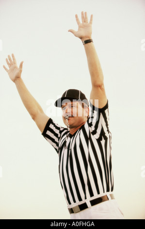 Football referee whistling with his arms raised Stock Photo - Alamy
